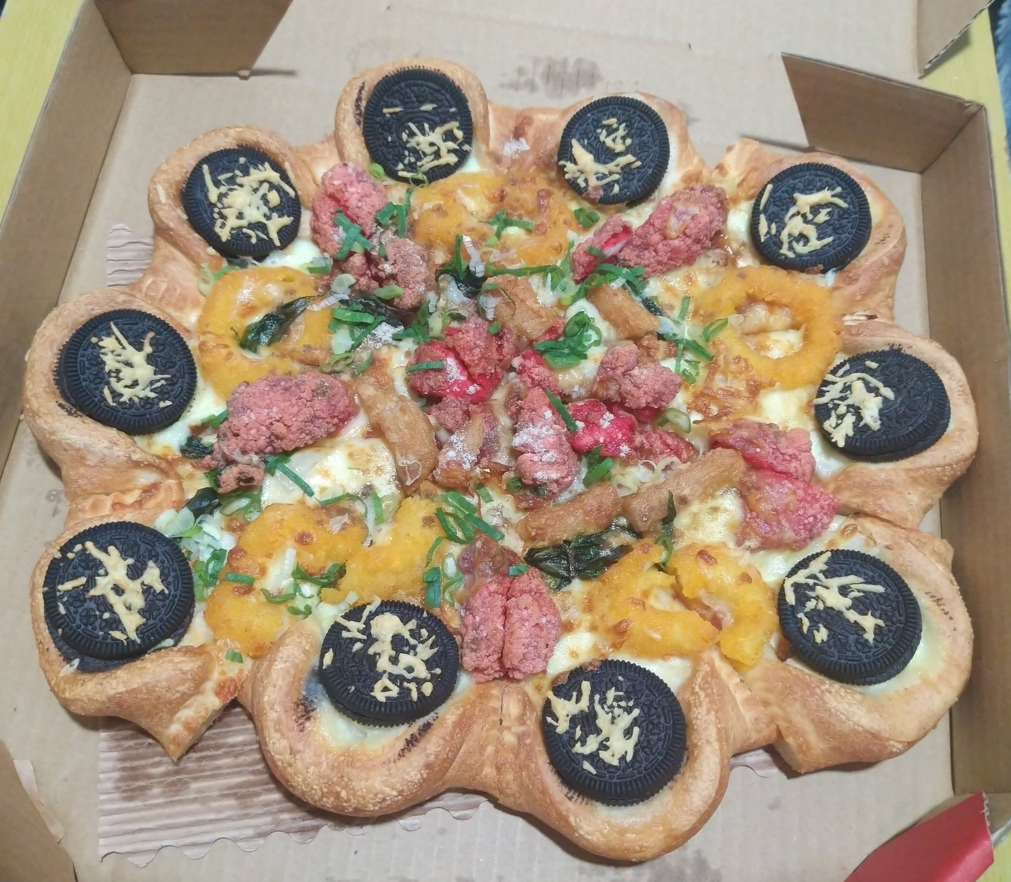 Crean la pizza con pollo, galletas y calamar... y pues se ve extraña